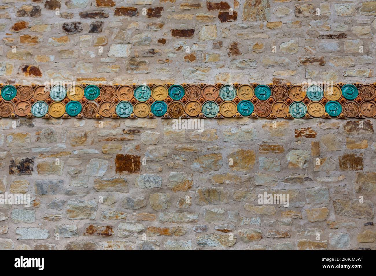 A view of the patterned stone wall with traditional symbols - a ...