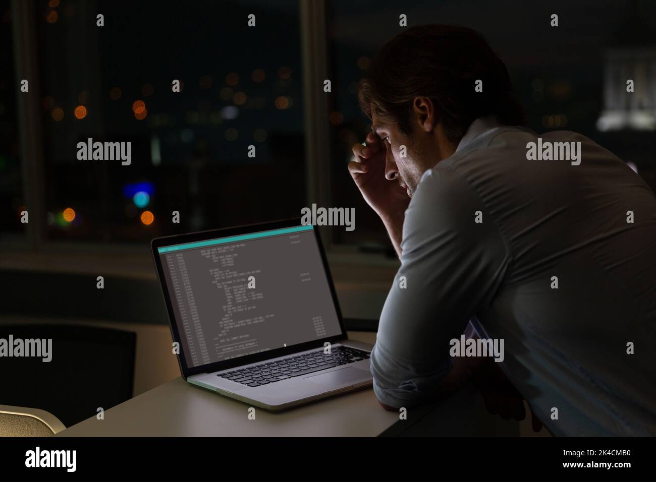 Caucasian male programmer sitting at desk, using laptop with coding on ...