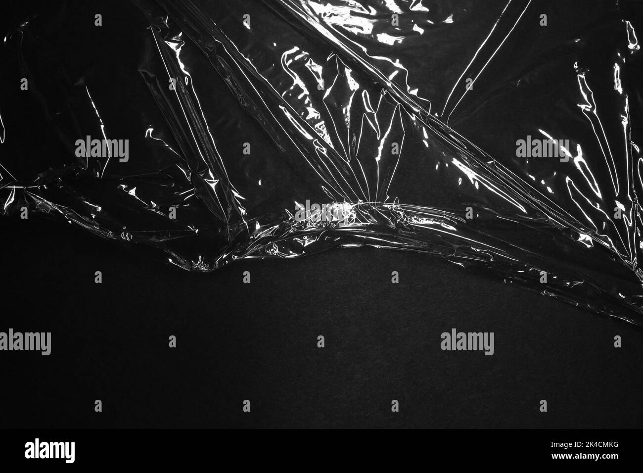 Reflecting light and shadow on creases and folds in clear plastic foil ...