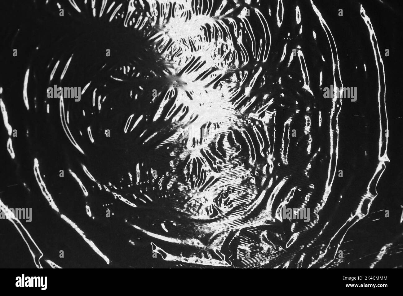 Reflecting light and shadow on creases and folds in black plastic ...