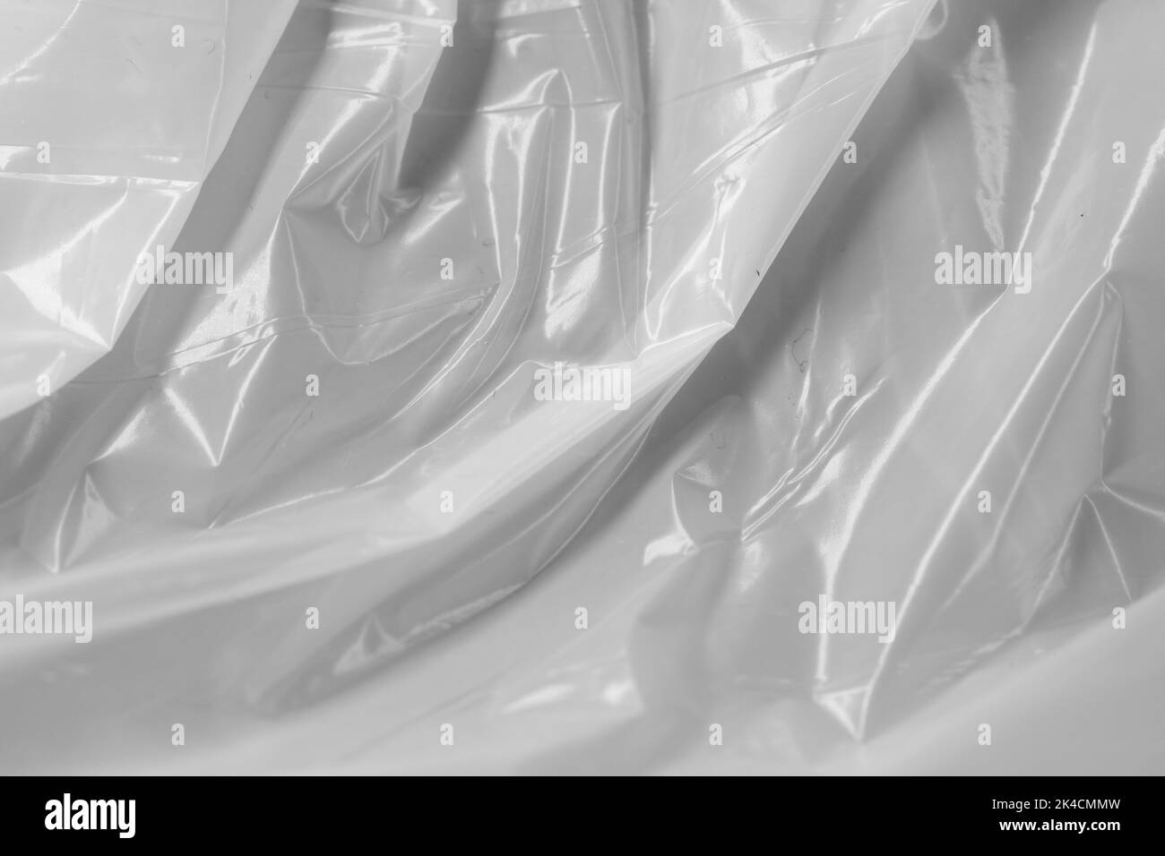 Reflecting light and shadow on creases and folds in white sheet of ...