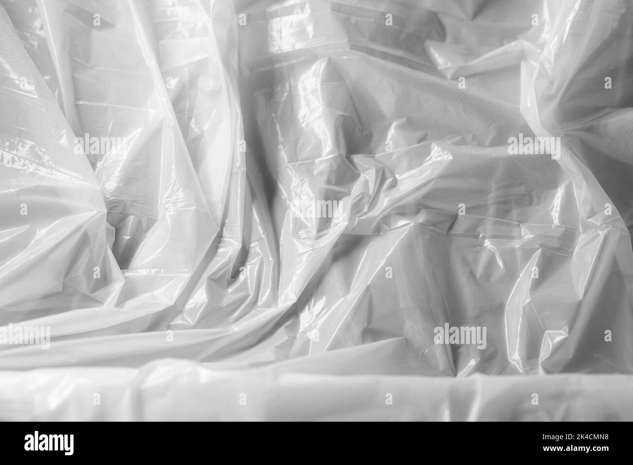 Reflecting light and shadow on creases and folds in white plastic ...