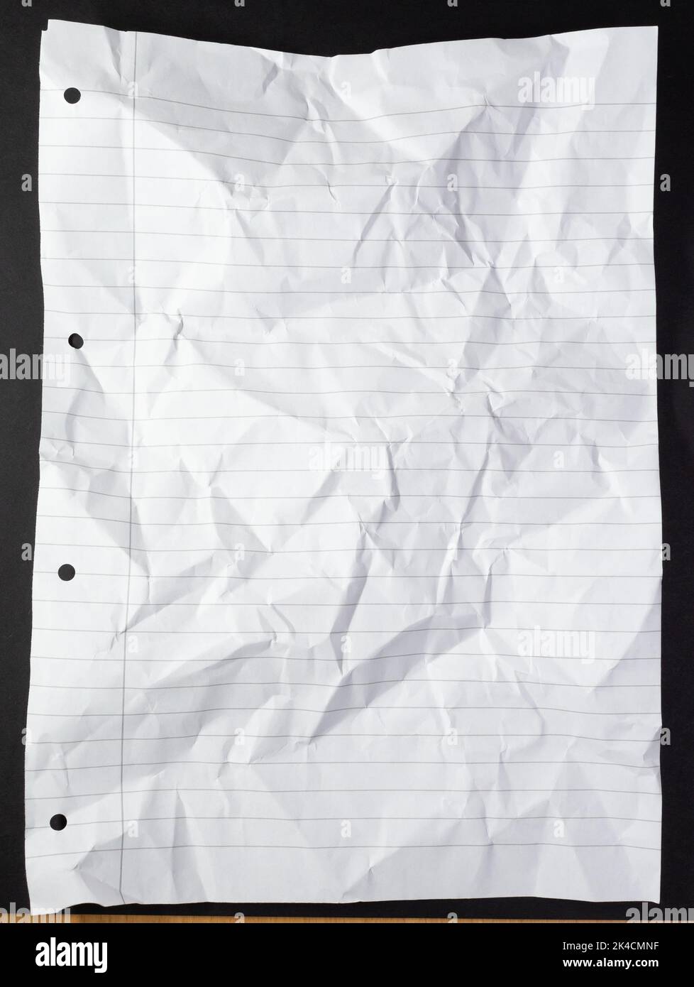 Light and shadow on creases in hole punched sheet of lined writing ...