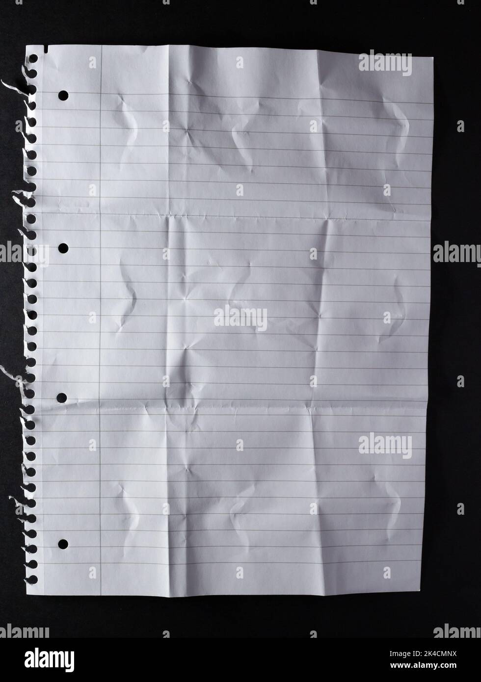 Folds and creases in hole punched sheet of lined paper with torn holes ...