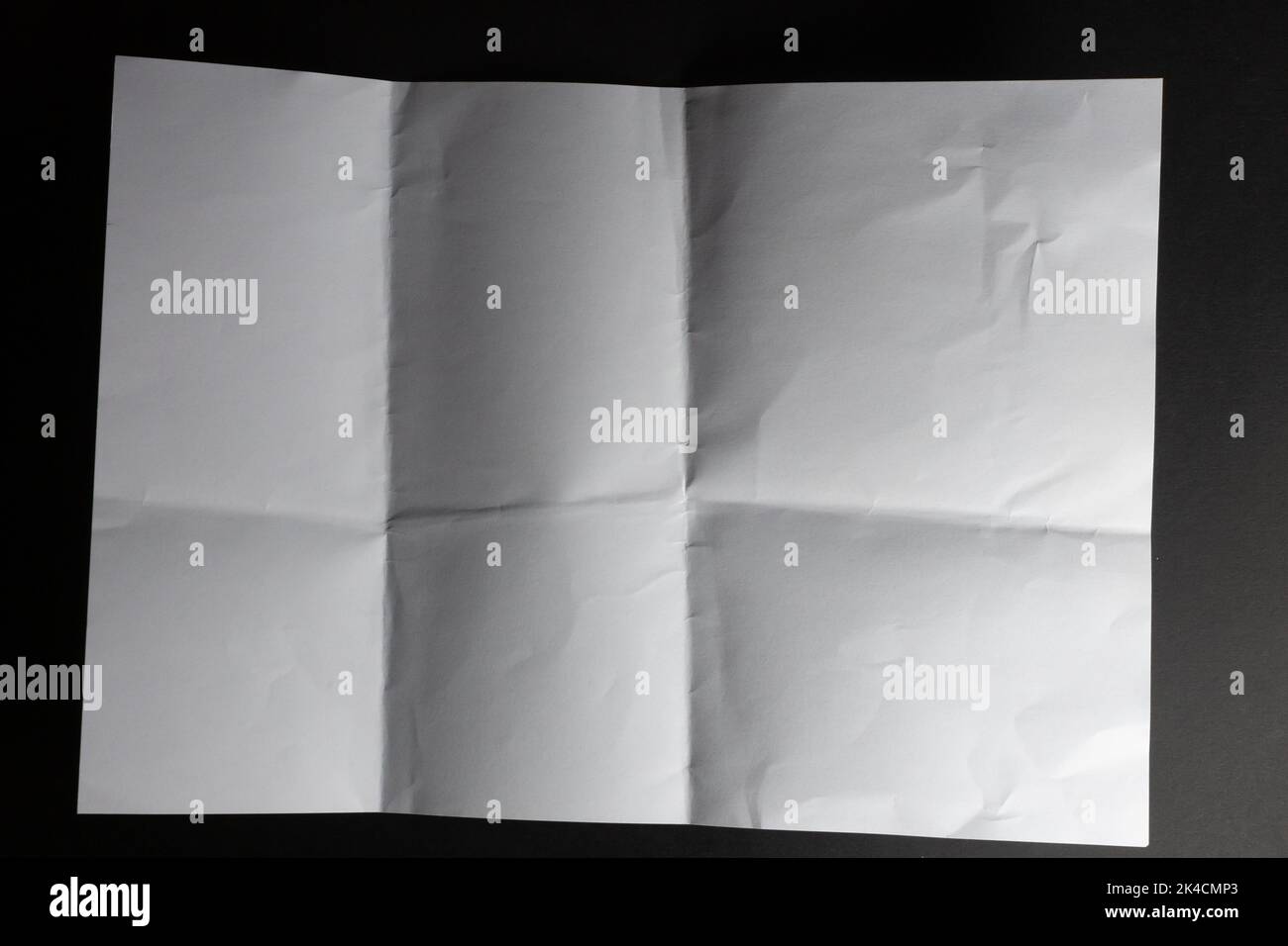 Light and shadow on creases in sheet of white paper folded into six ...