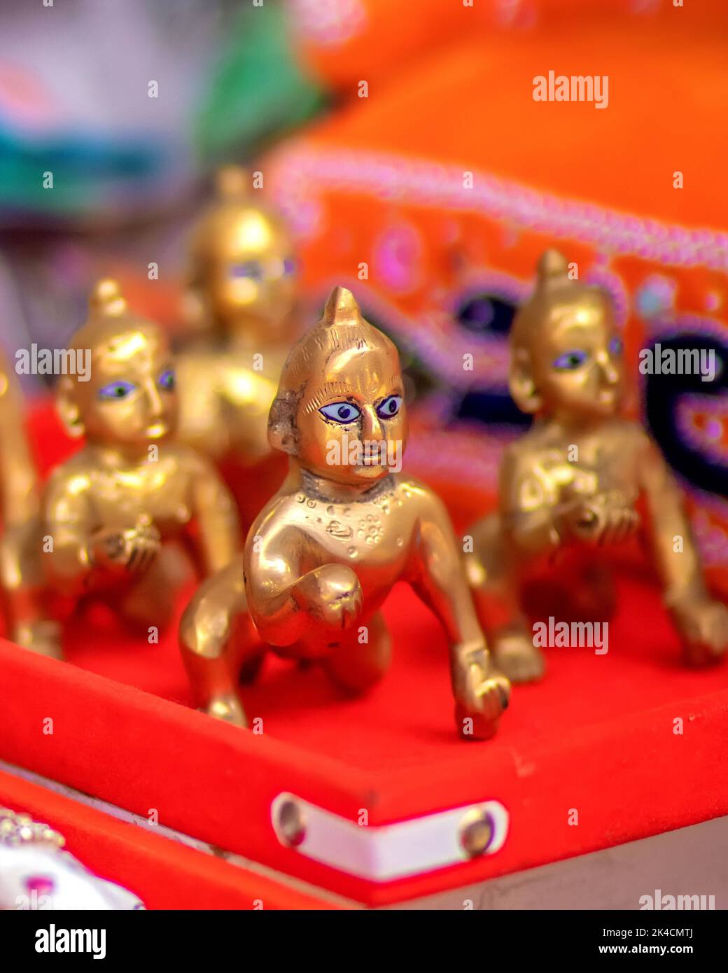 A vertical shot of small golden souvenirs of Lord Krishna in the ...