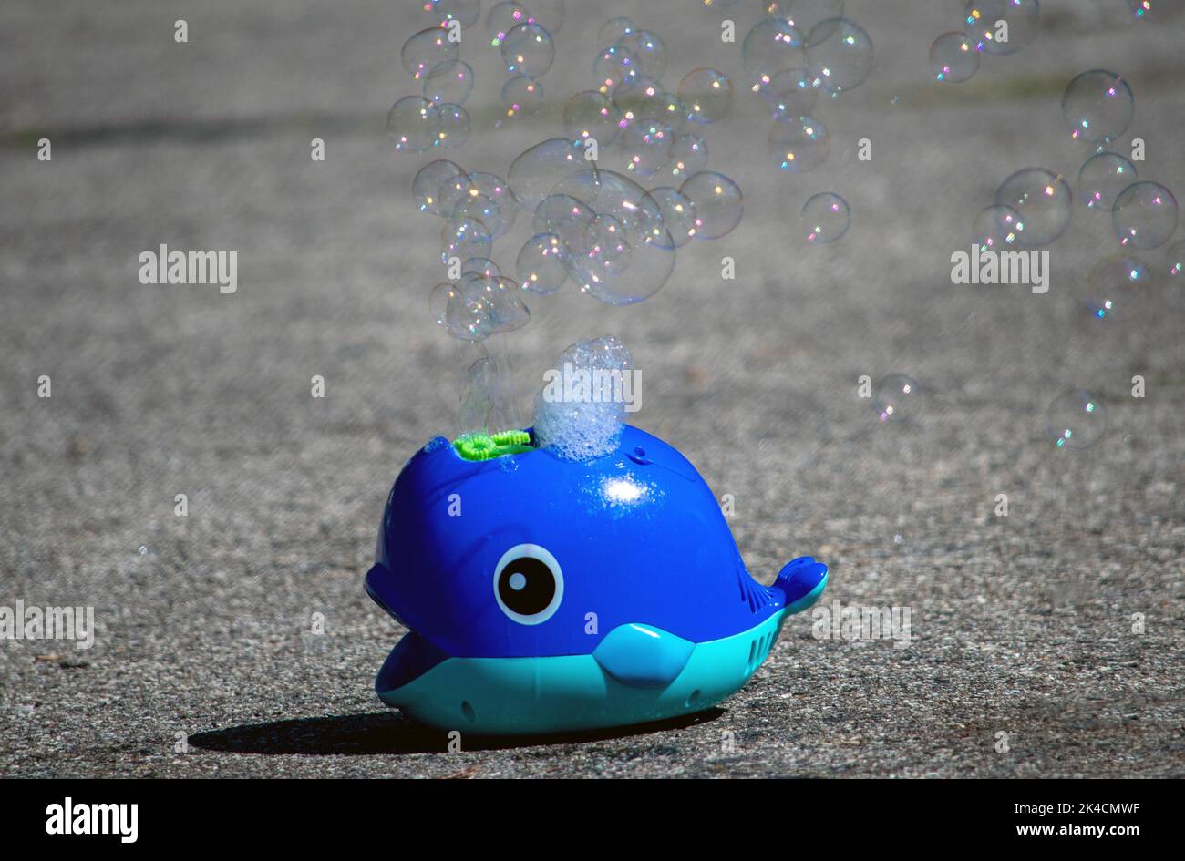 blue plastic bubble machine blows soap bubbles into the air Stock Photo ...