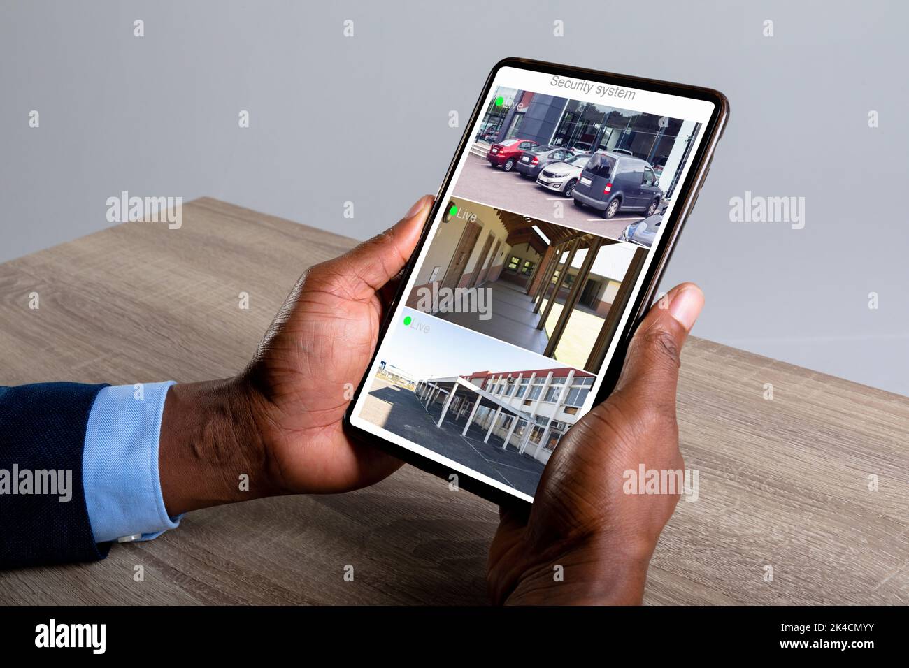 Hands of caucasian man holding smartphone with view from security ...