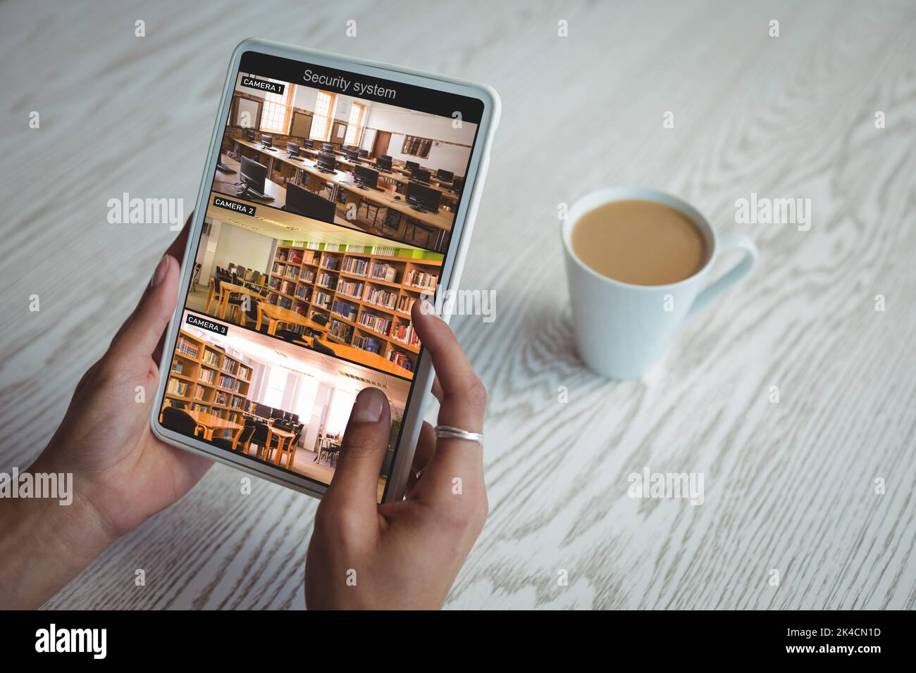 Hands of caucasian woman holding tablet with view of library from ...
