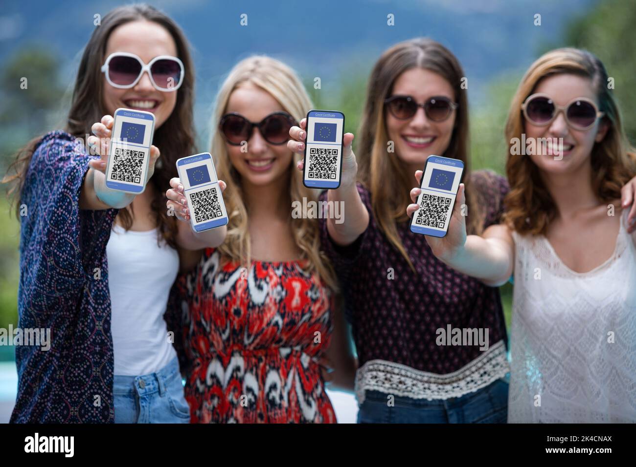 Beautiful women smiling and showing their mobile phones Stock Photo - Alamy