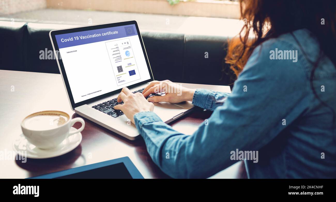 Caucasian woman using laptop with covid vaccination certificate and qr ...