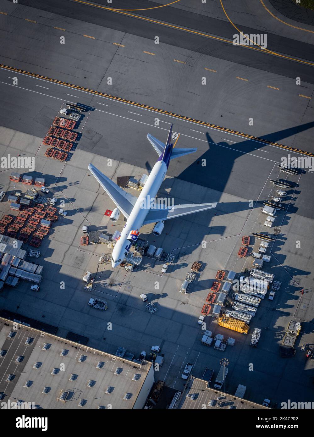 A vertical aerial top shot a FedEx cargo plane being loaded up at ...