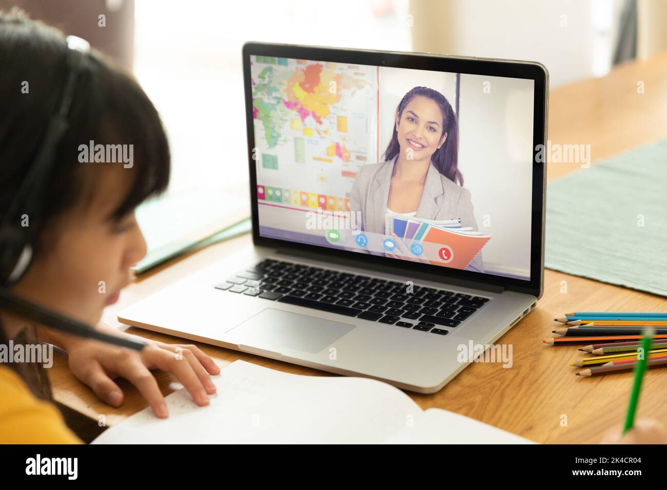Asian girl using laptop for video call, with smiling female teacher on ...
