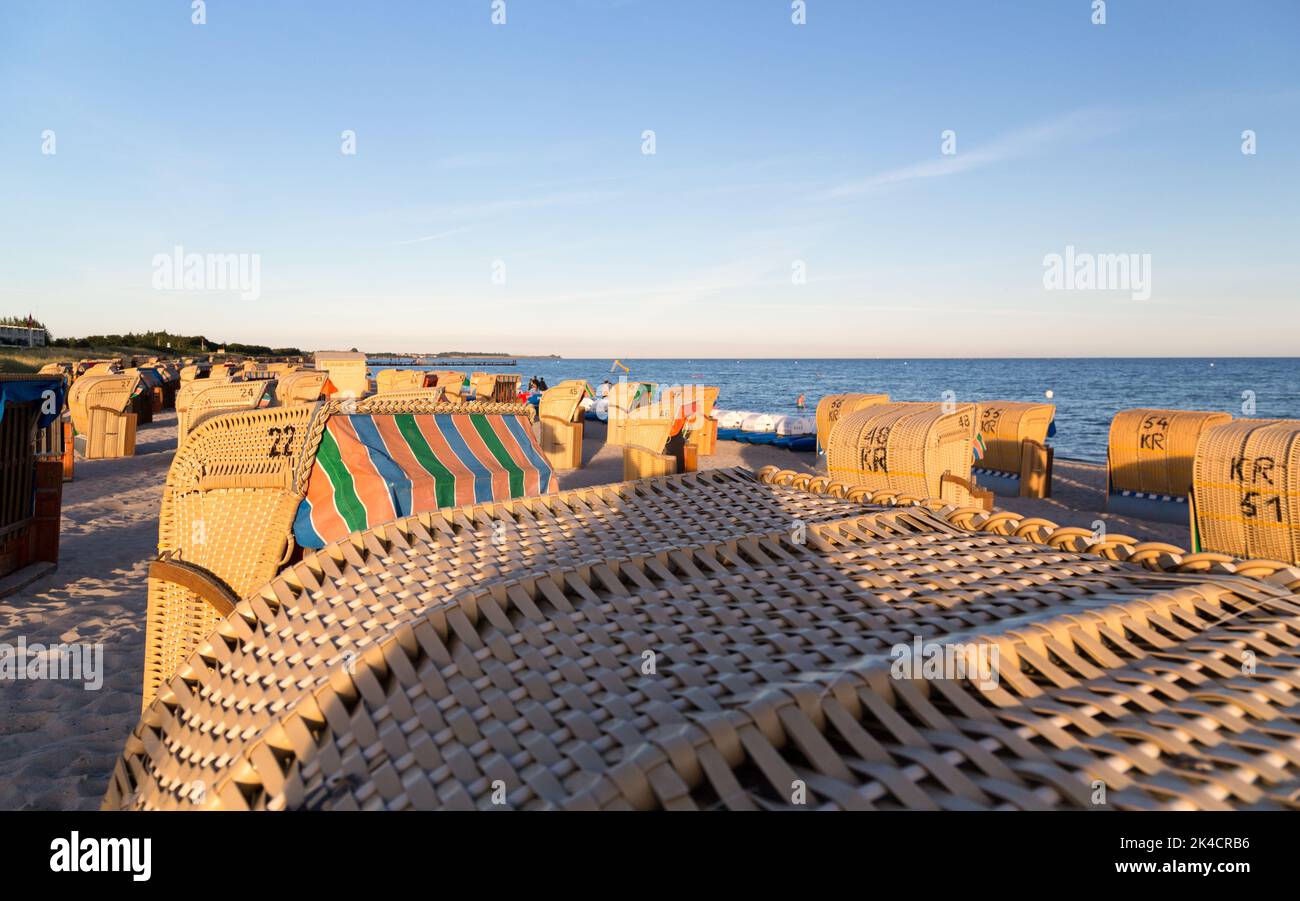A closeup shot of wooden hooded beach chairs on the ocean shore on a ...