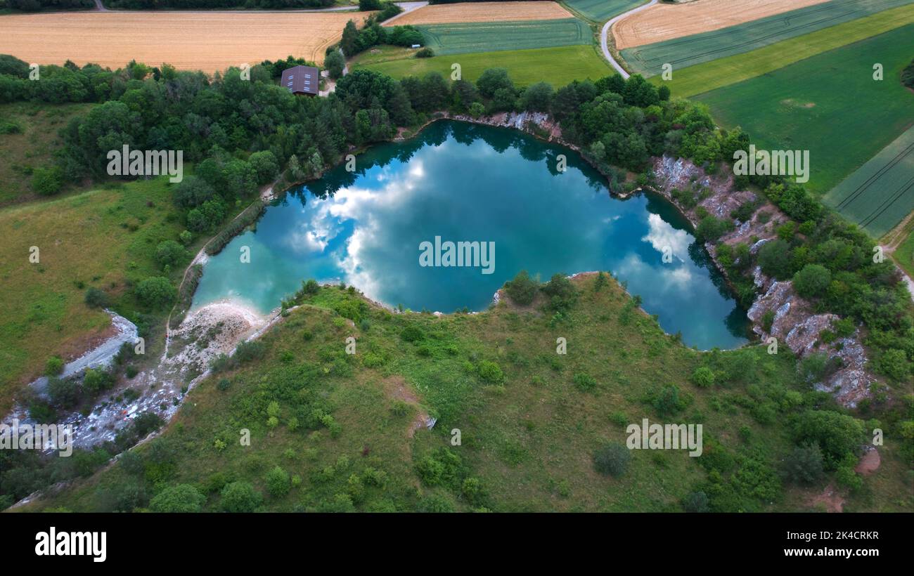 An aerial view of a lake surrounded by green plant fields in Germany ...