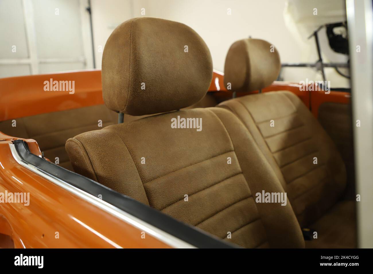 A closeup of empty soft brown car seats with open roof parked in a ...
