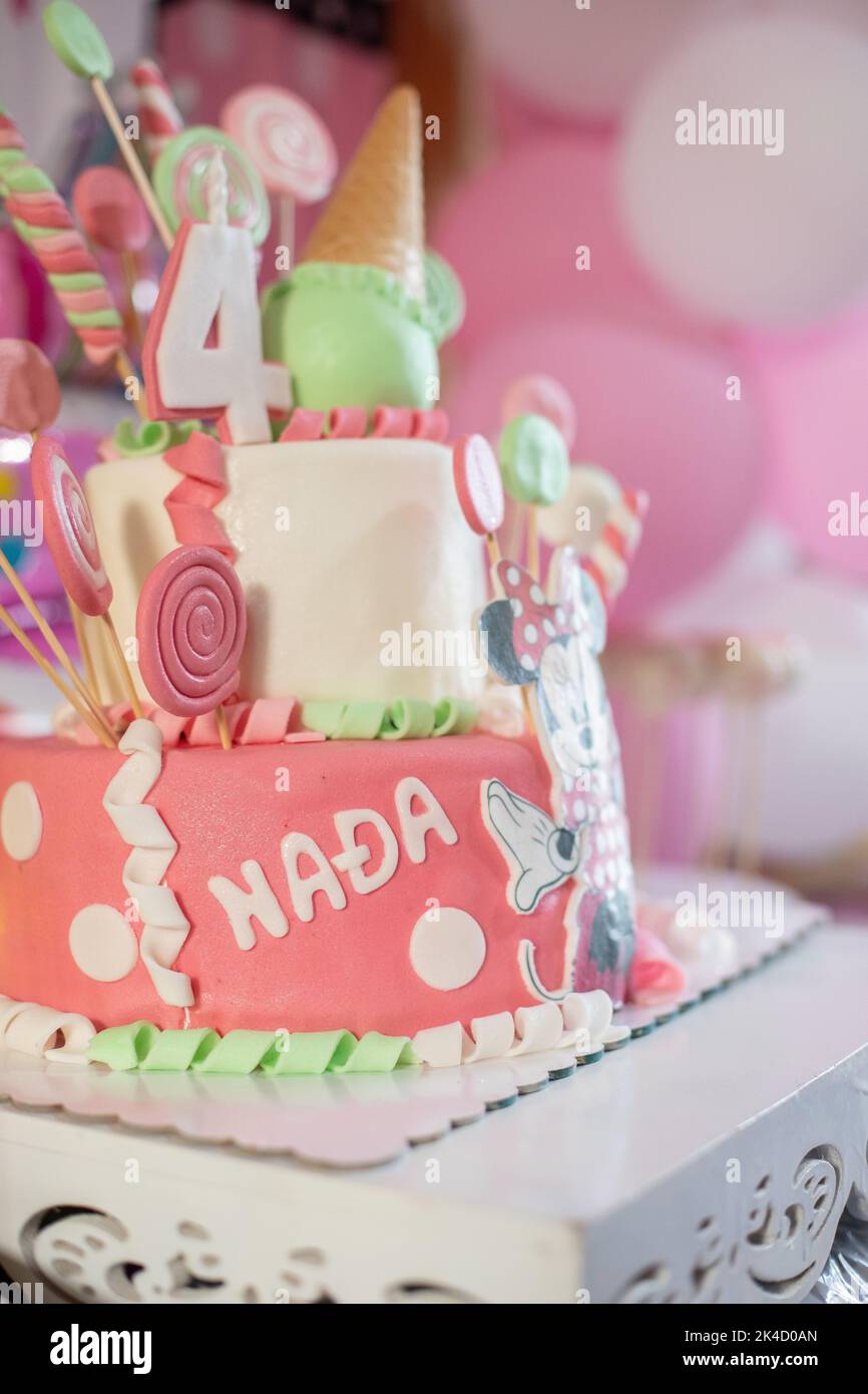 A vertical closeup shot of a creative two-tier cake with sweets for a ...