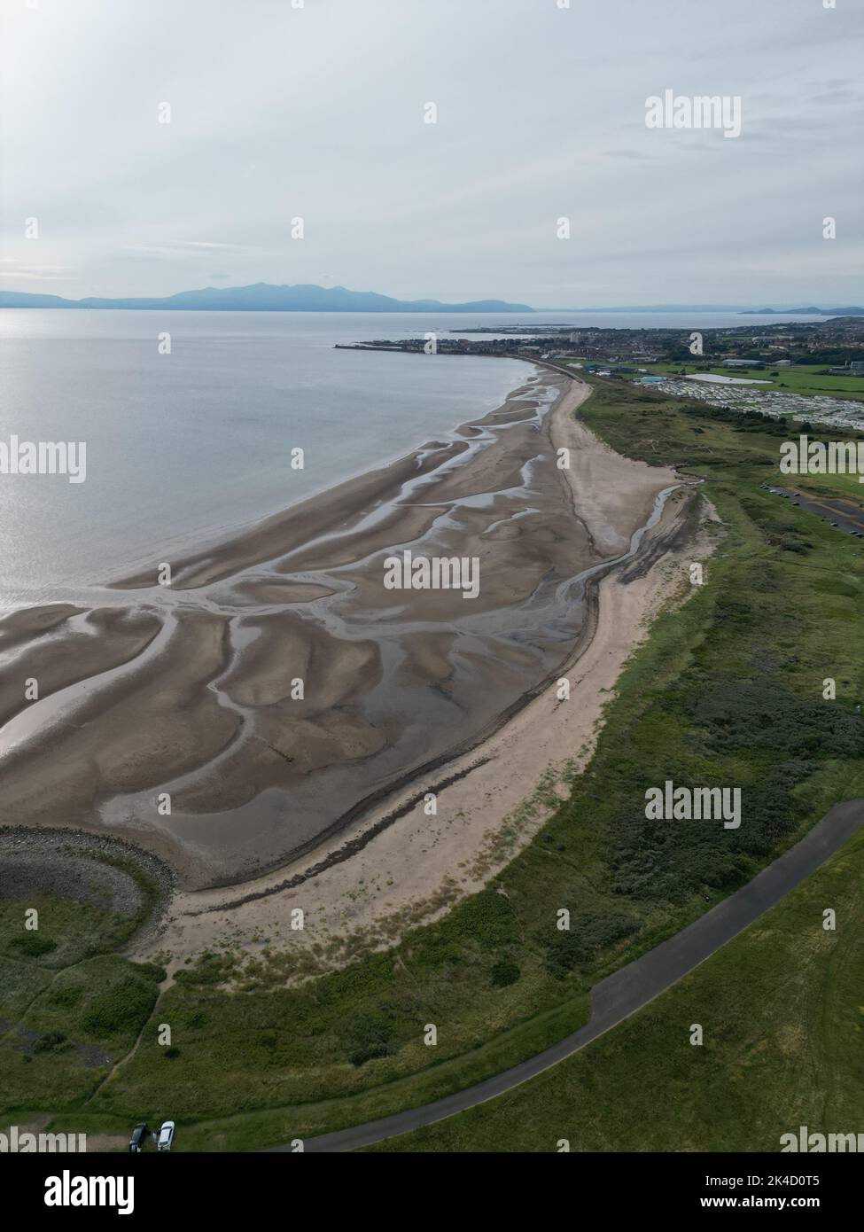 An aerial view of largegreen beach by the blue sea under gray cloudy ...