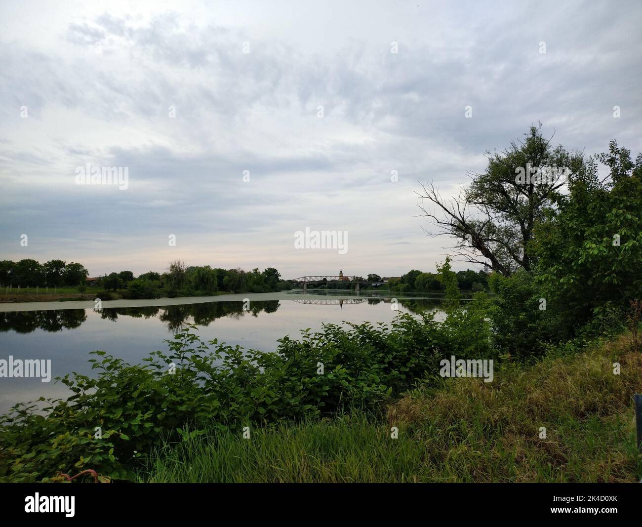 A beautiful natural scenery of a river flowing in a village surrounded ...