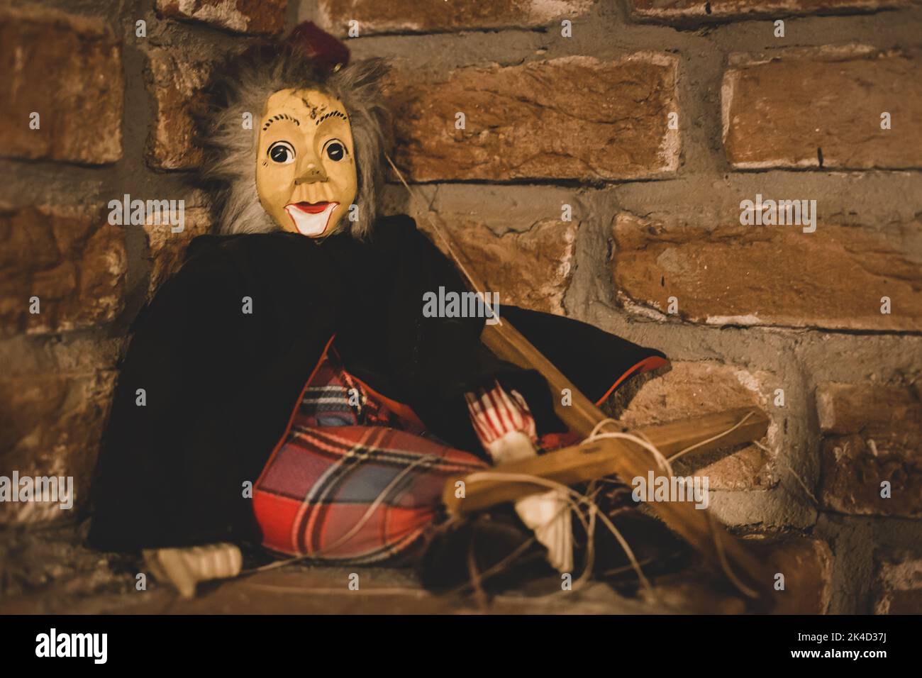 A vintage wooden puppet in form of a clown against a brick wall Stock ...