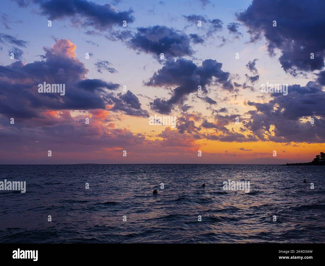 A scenic sunset in the Rab island, in Croatia with yellow cloudy sky ...