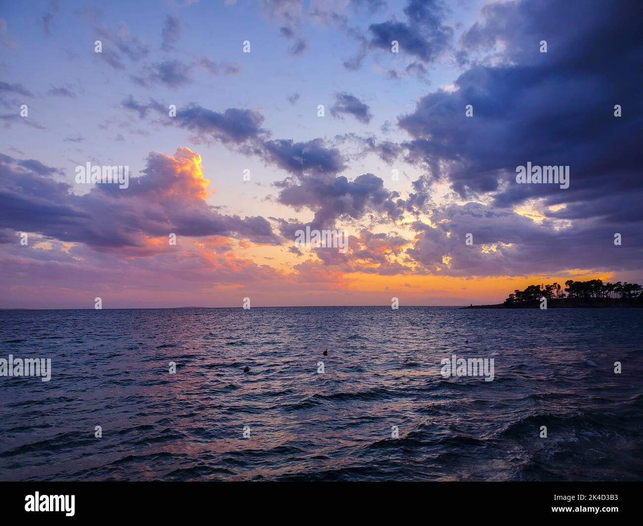 A scenic sunset in the Rab island, in Croatia with yellow cloudy sky ...
