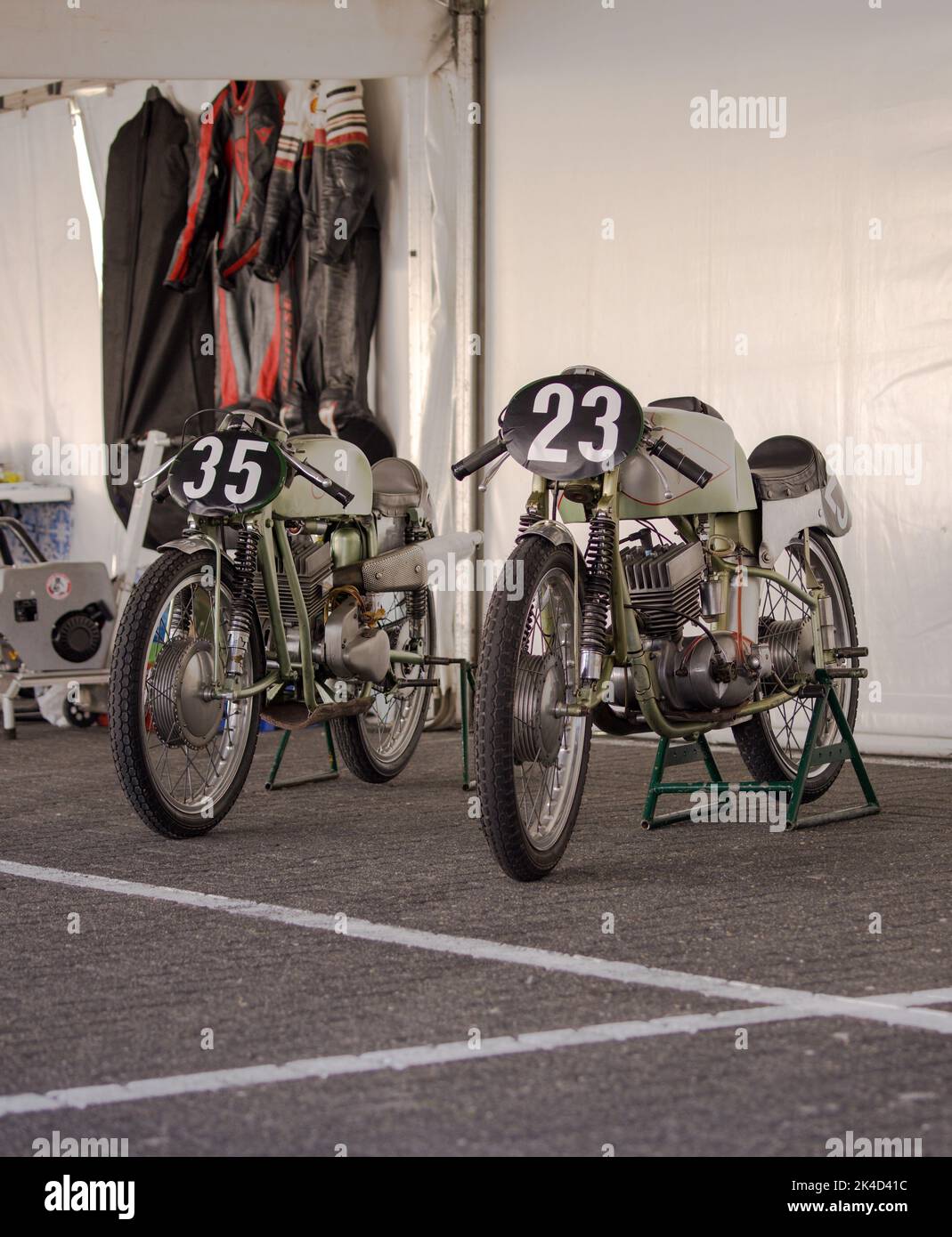 A vertical shot of two motorcycles with numbers on them, prepared for a ...