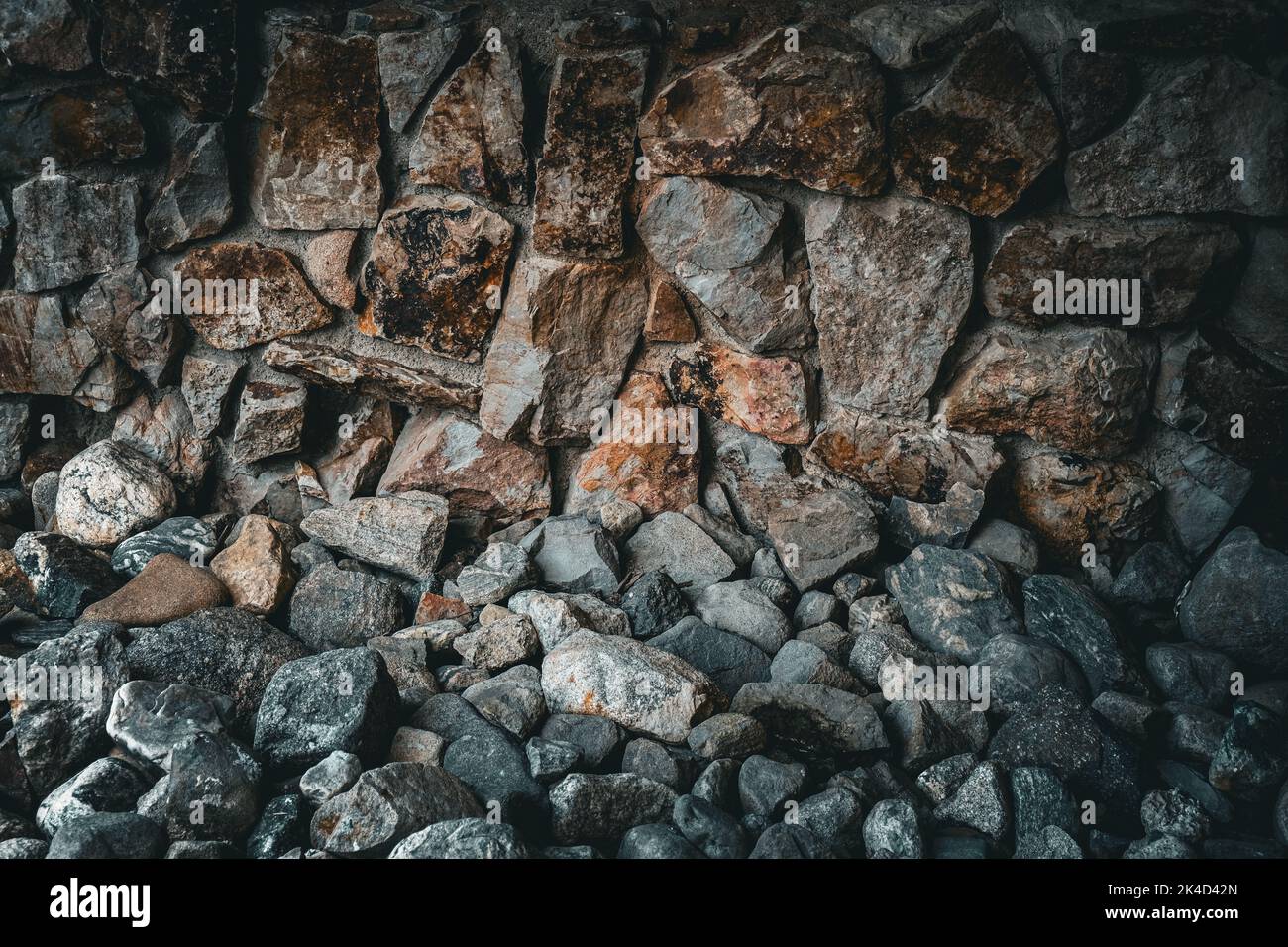 A pile of old rocks gathered together under dim lighting - weathered ...