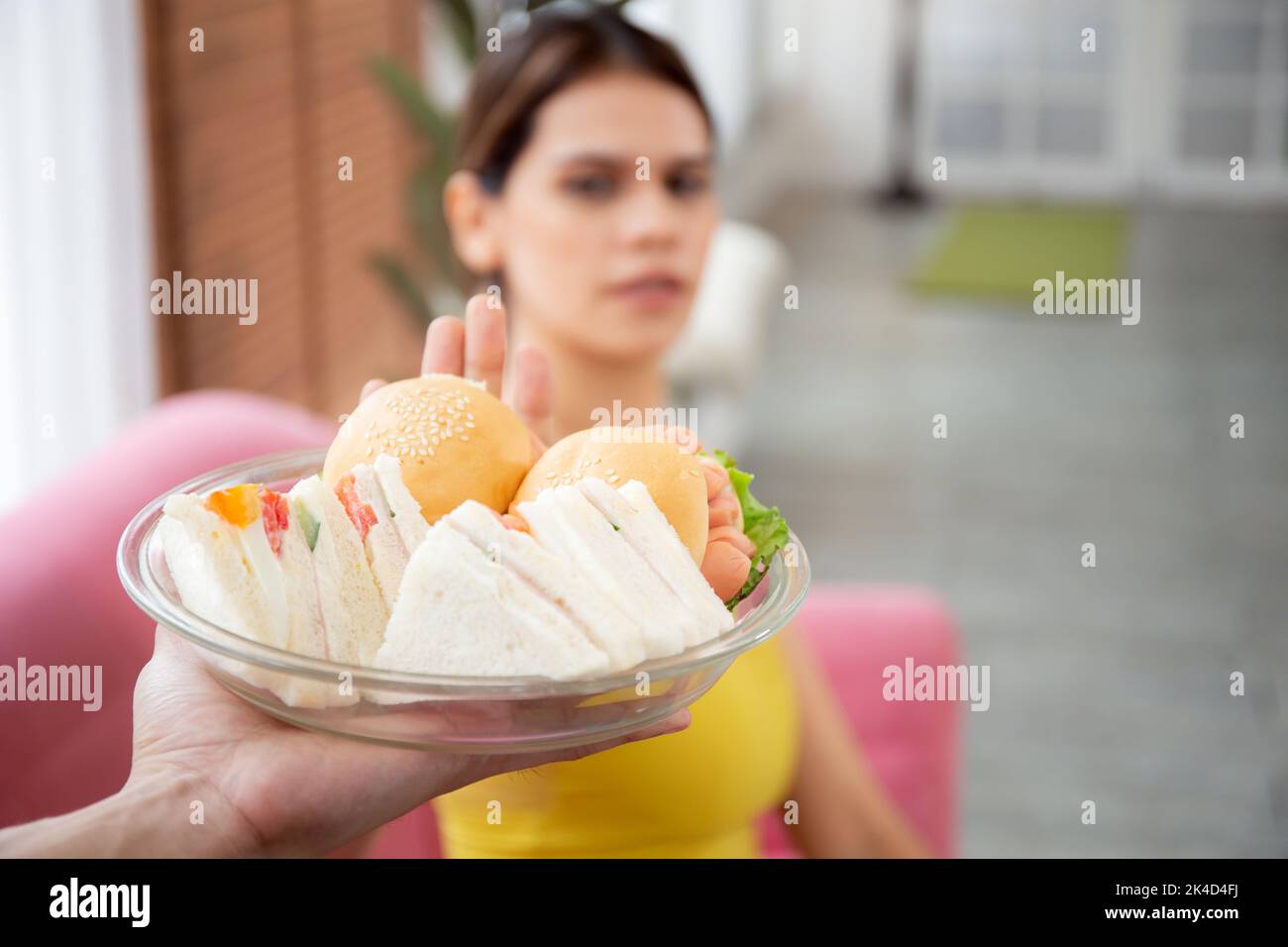 Hands serving food and young caucasian woman making sign say no food ...