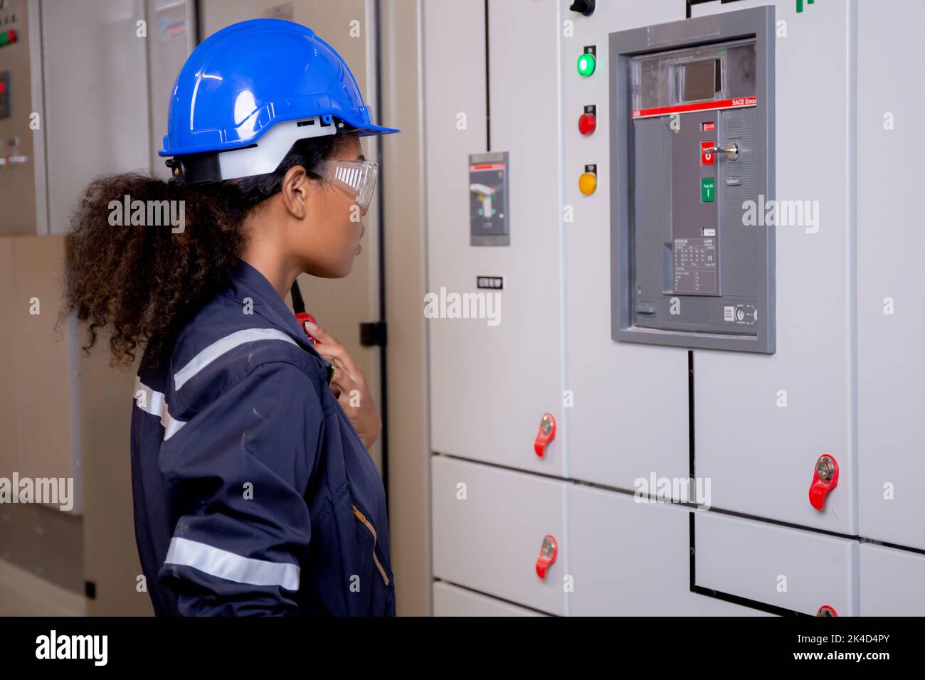 Electrical young asian woman engineer examining maintenance cabinet ...