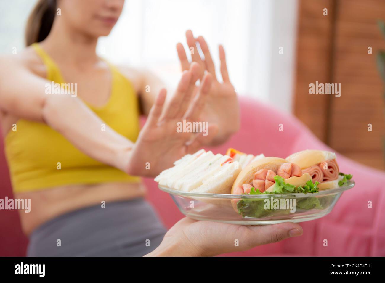 Hands serving food and young caucasian woman making sign say no food ...