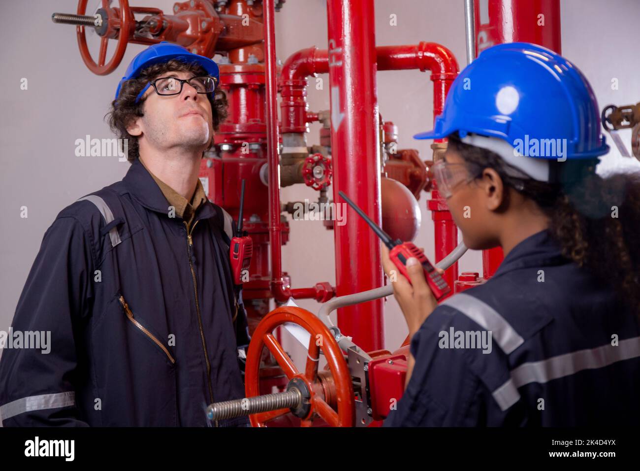 Young woman and man engineer check and examining pipeline and using ...