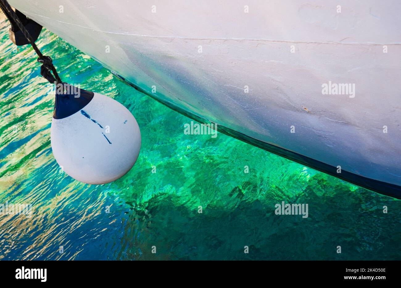 A closeup of an anchor of a white ship above blue water Stock Photo - Alamy