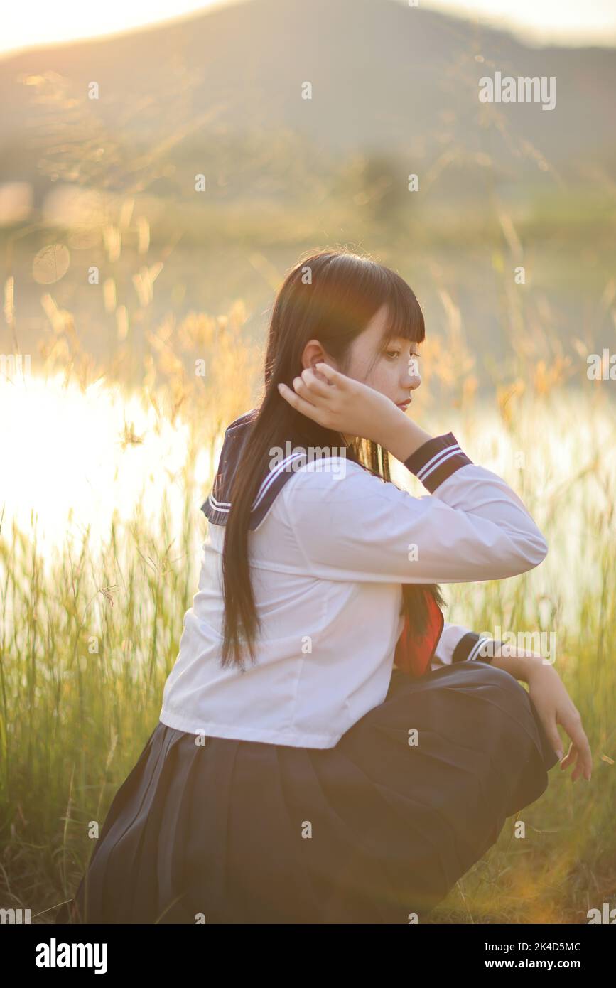 Asian High School Girls student sitting and looking at camera in countryside with sunrise Stock ...
