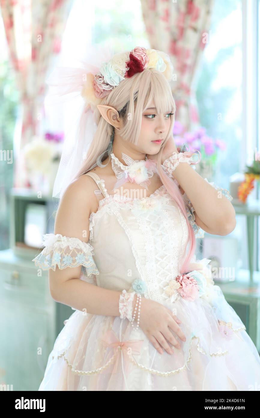 Beautiful young woman with white lolita dress with flowers garden ...