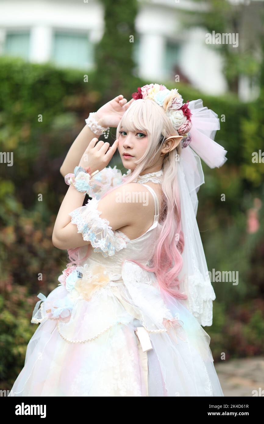 Beautiful young woman with white lolita dress with flowers garden ...