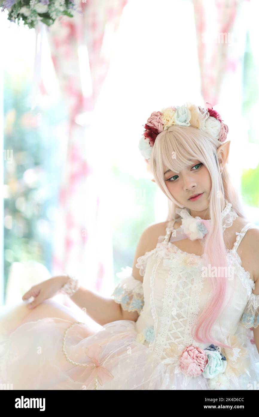 Beautiful young woman with white lolita dress with flowers garden ...