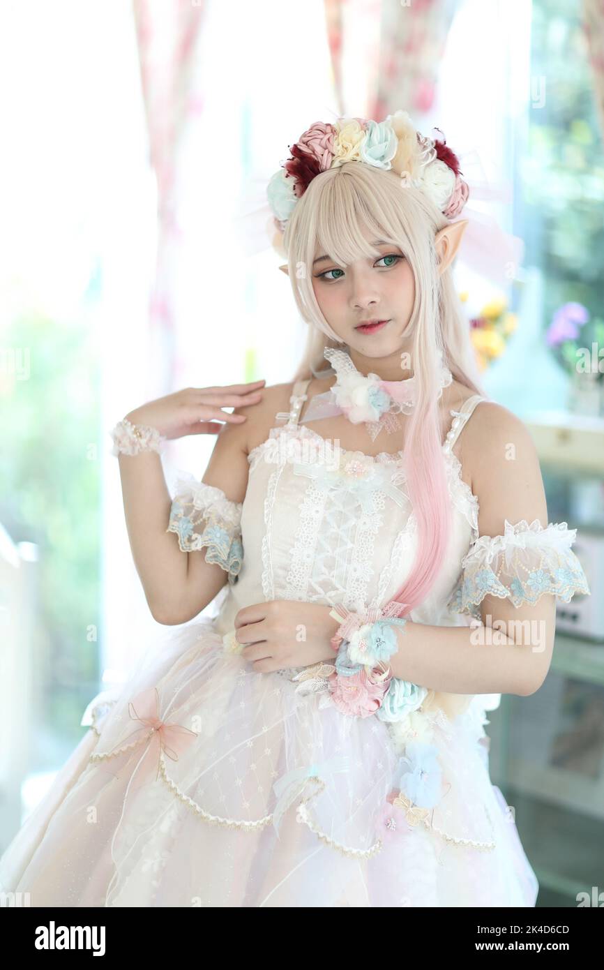 Beautiful young woman with white lolita dress with flowers garden ...