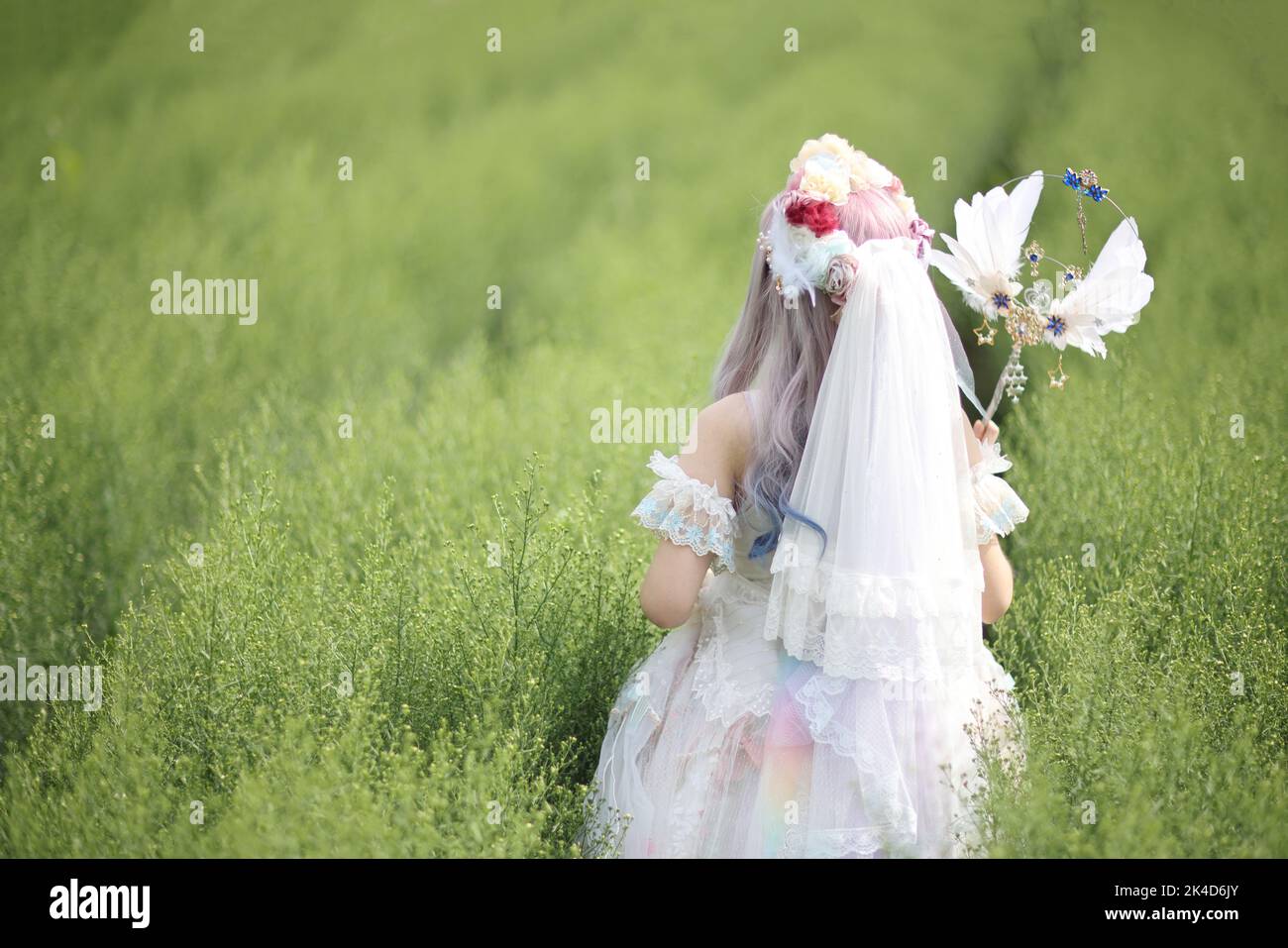 Beautiful young woman with white lolita dress with flowers garden ...