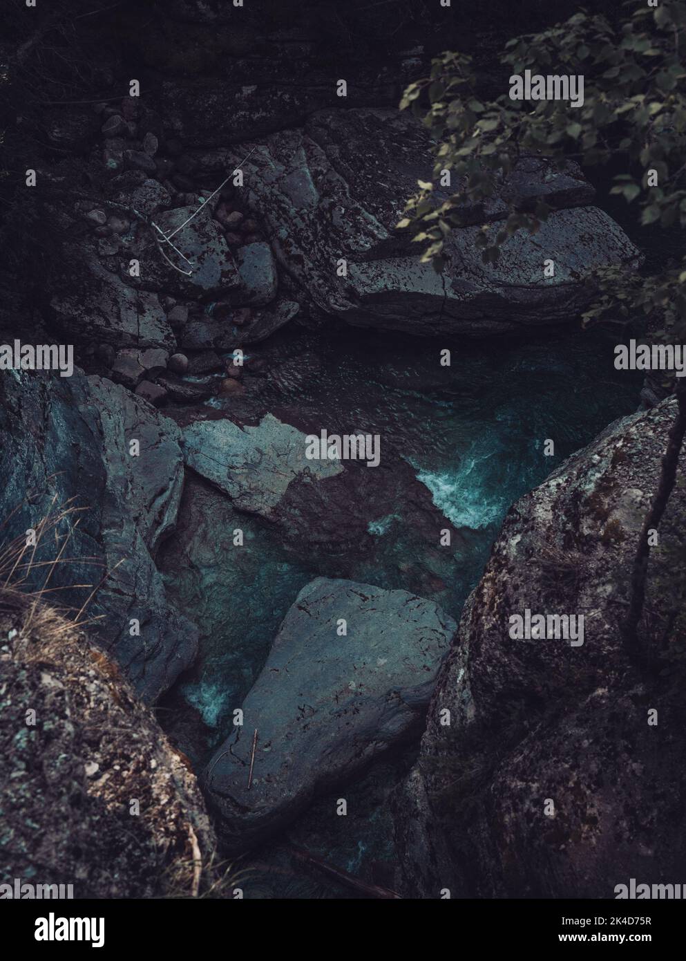 A vertical shot of a river surrounded by rocks in Jasper National Park ...