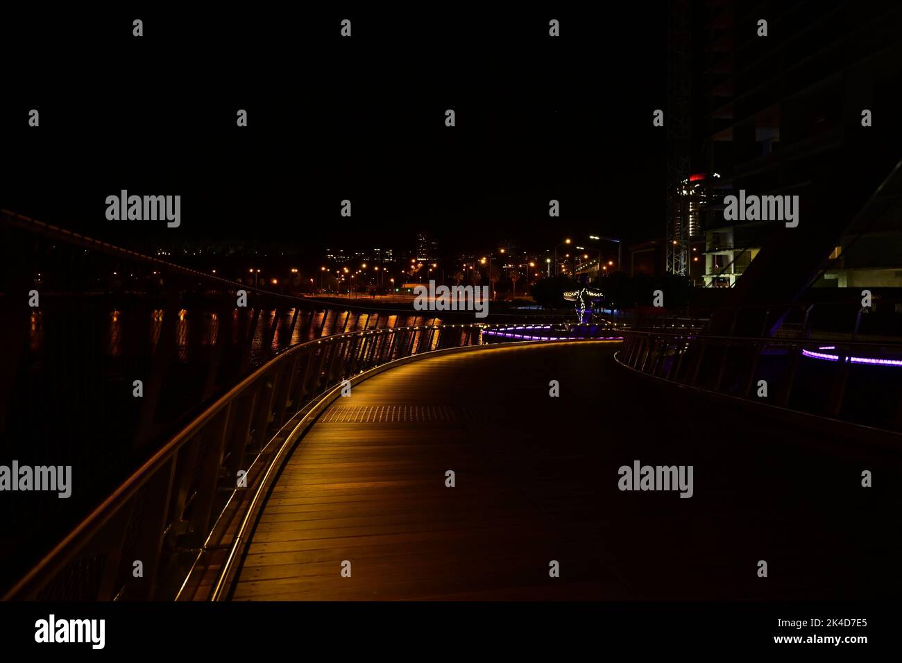 A beautiful night cityscape with dimly lit walkway on the bridge at ...