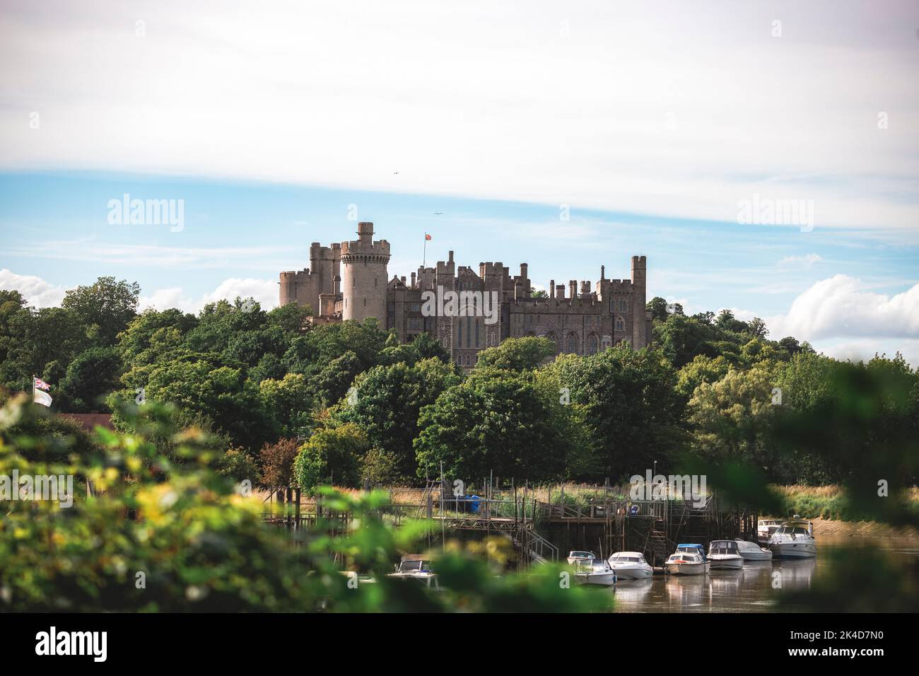 The majestic British Arundel castle shaded by trees from a distance ...