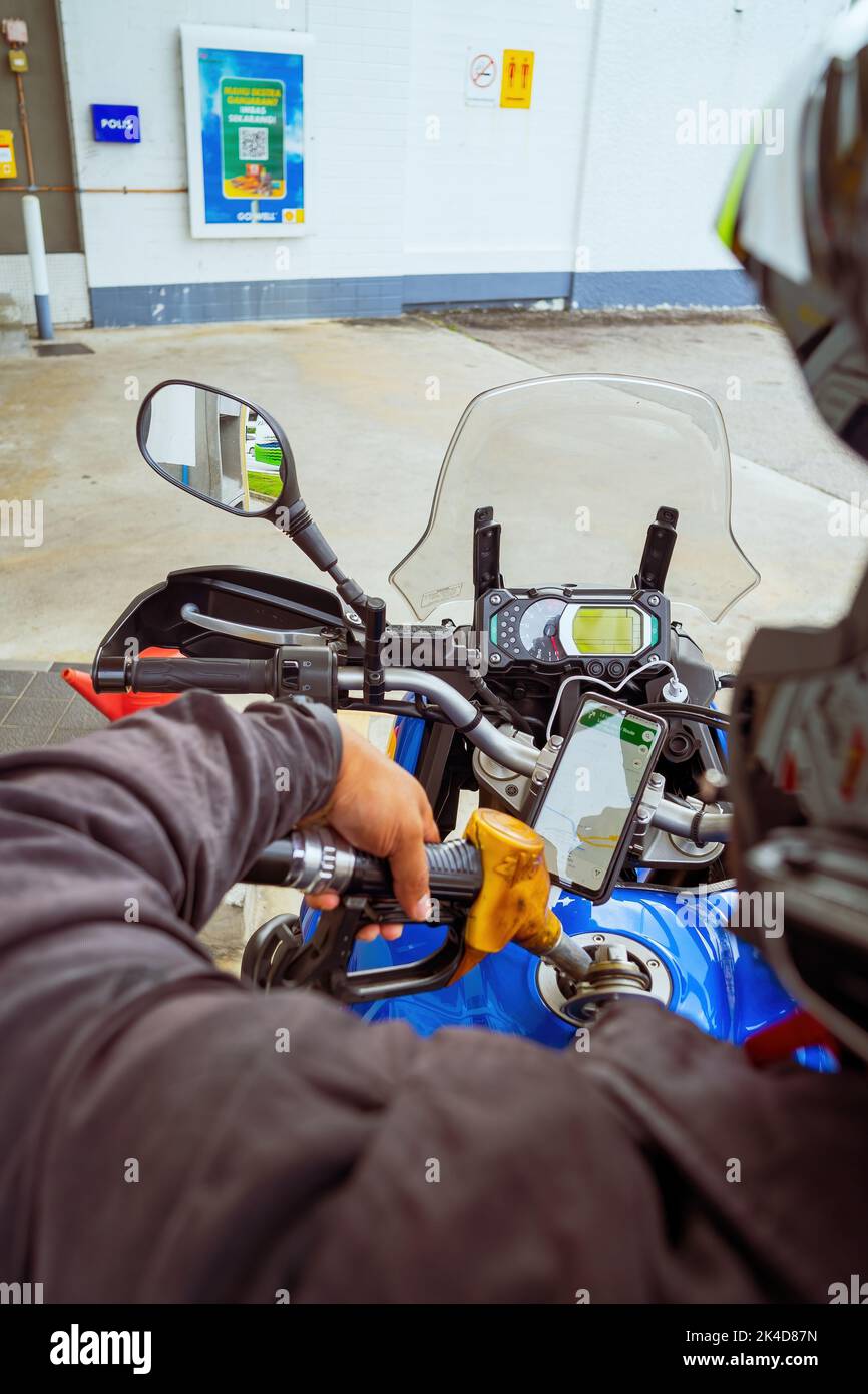 A motorcycle refueling at the gas station, viewed from behind Stock ...