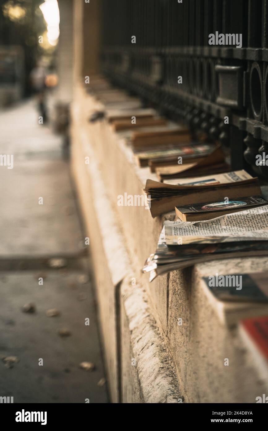 Vertical street photo of books lying on the street Stock Photo - Alamy