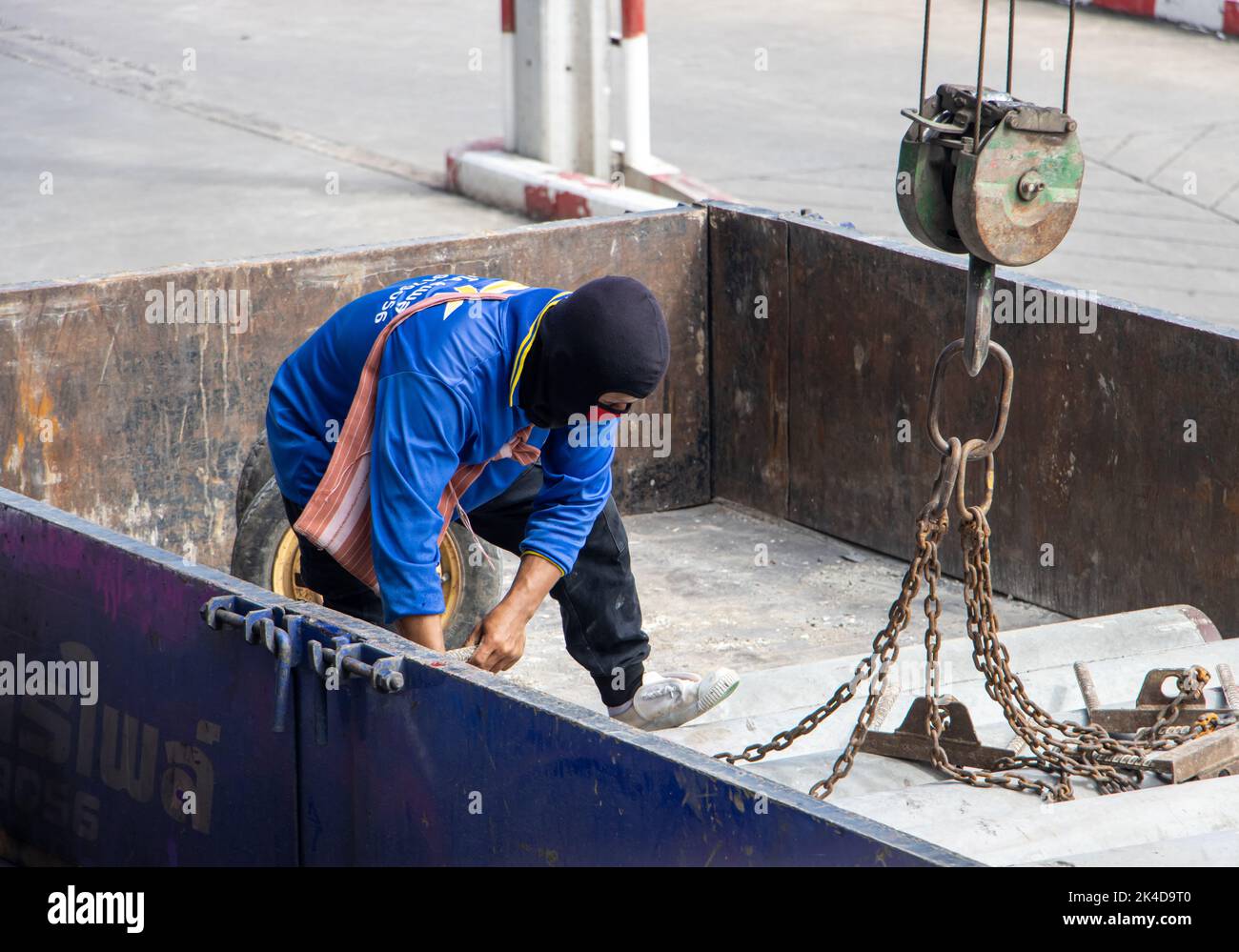 SAMUT PRAKAN, THAILAND, SEP 16 2022, A worker attaches chains from a ...