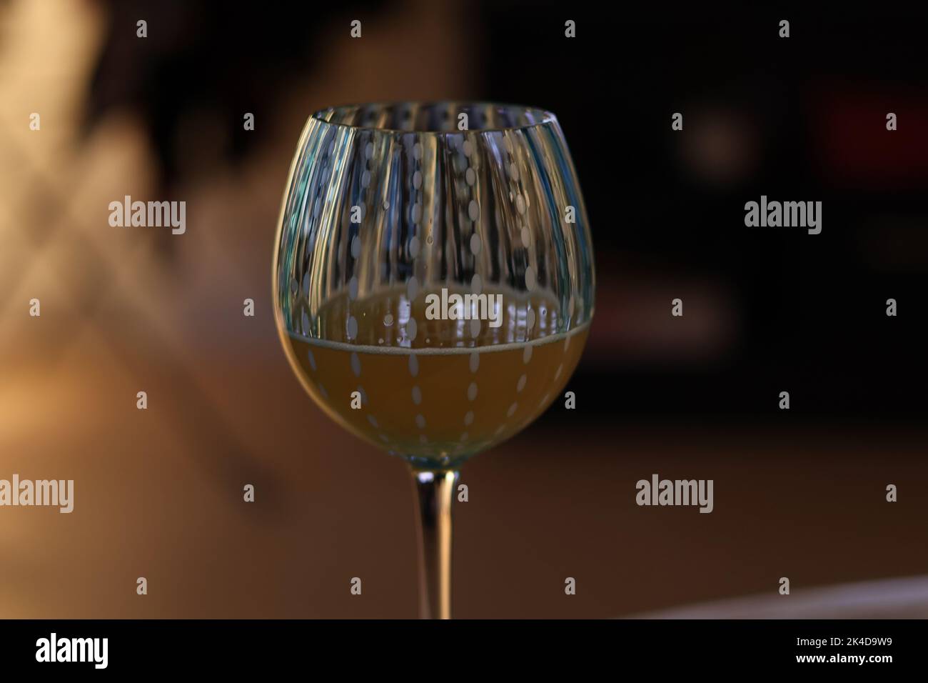 Beautiful half-full glass in a dimmed-light room with nice blured ...