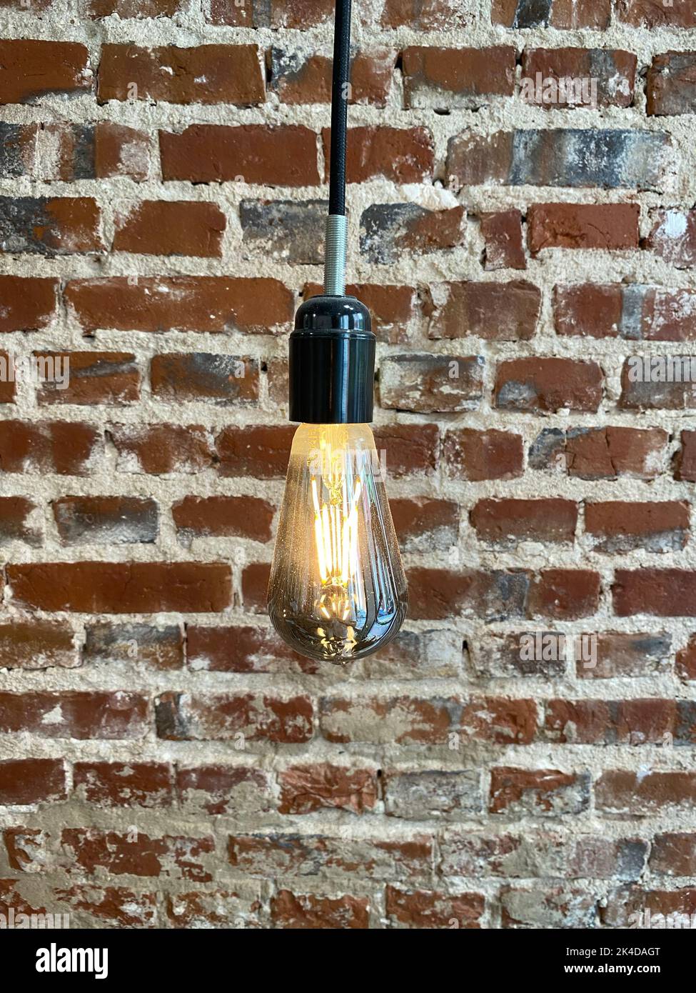 a vertical shot of a light bulb against a vintage brick wall Stock ...