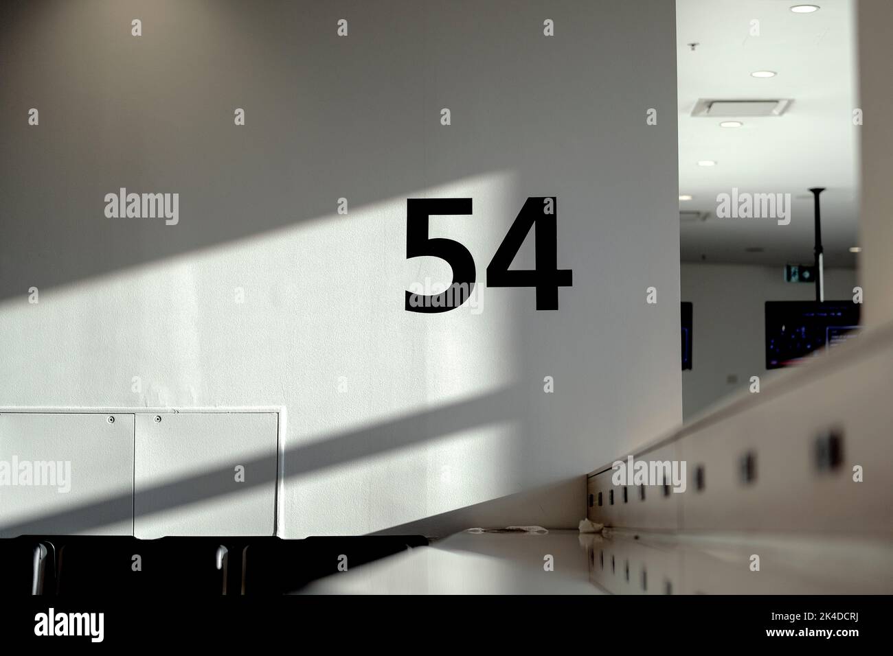 A closeup of a 54 number on a white concrete wall Stock Photo - Alamy