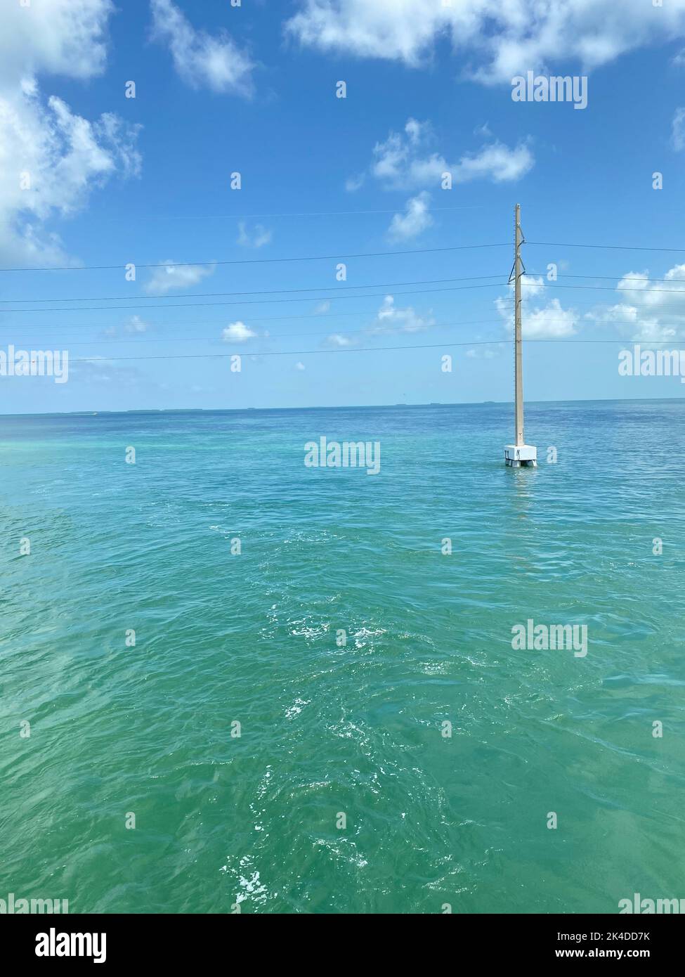 A vertical shot of an electric pylon in the ocean Stock Photo - Alamy