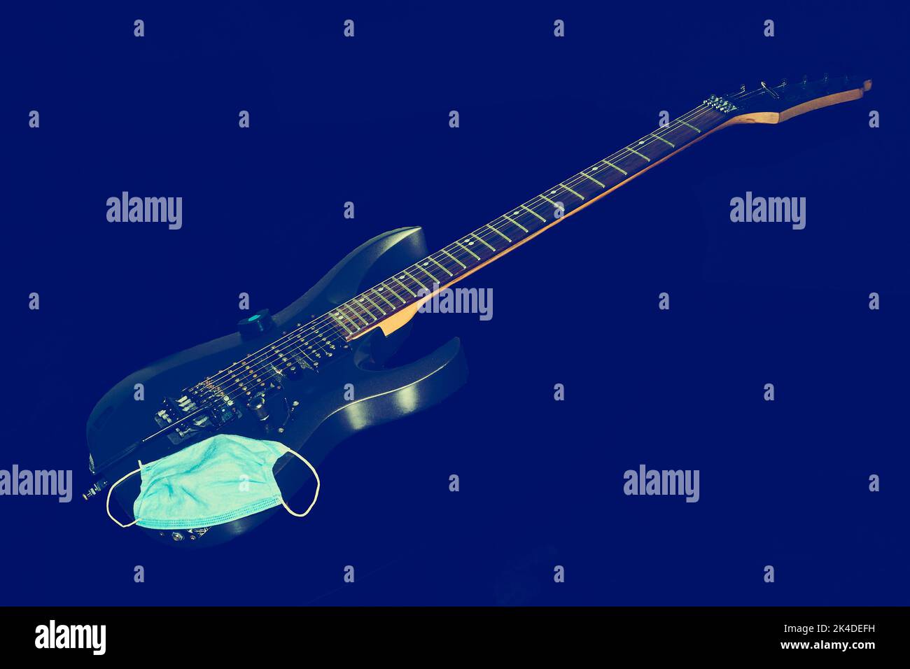 Dark electric guitar with a protective mask on a black background Stock ...